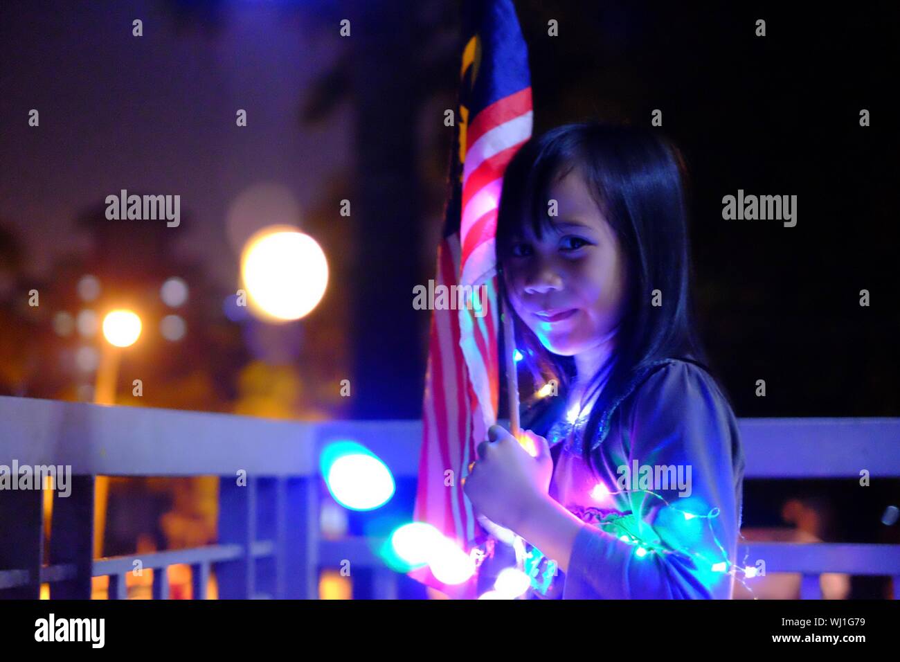 Portrait Of Smiling Girl Holding Flag At Night Stock Photo - Alamy