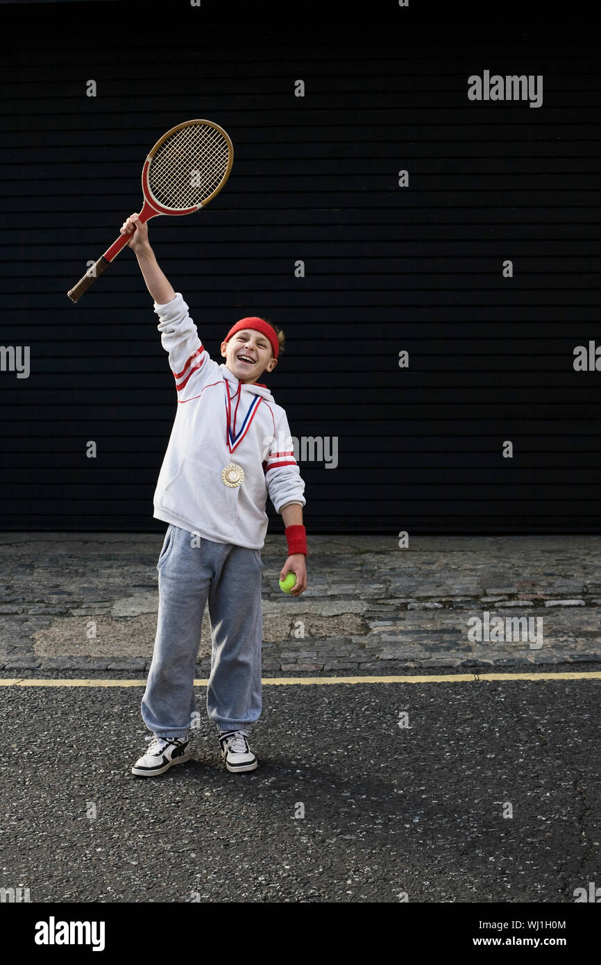 Full length of an excited young male winner raising tennis racket Stock ...