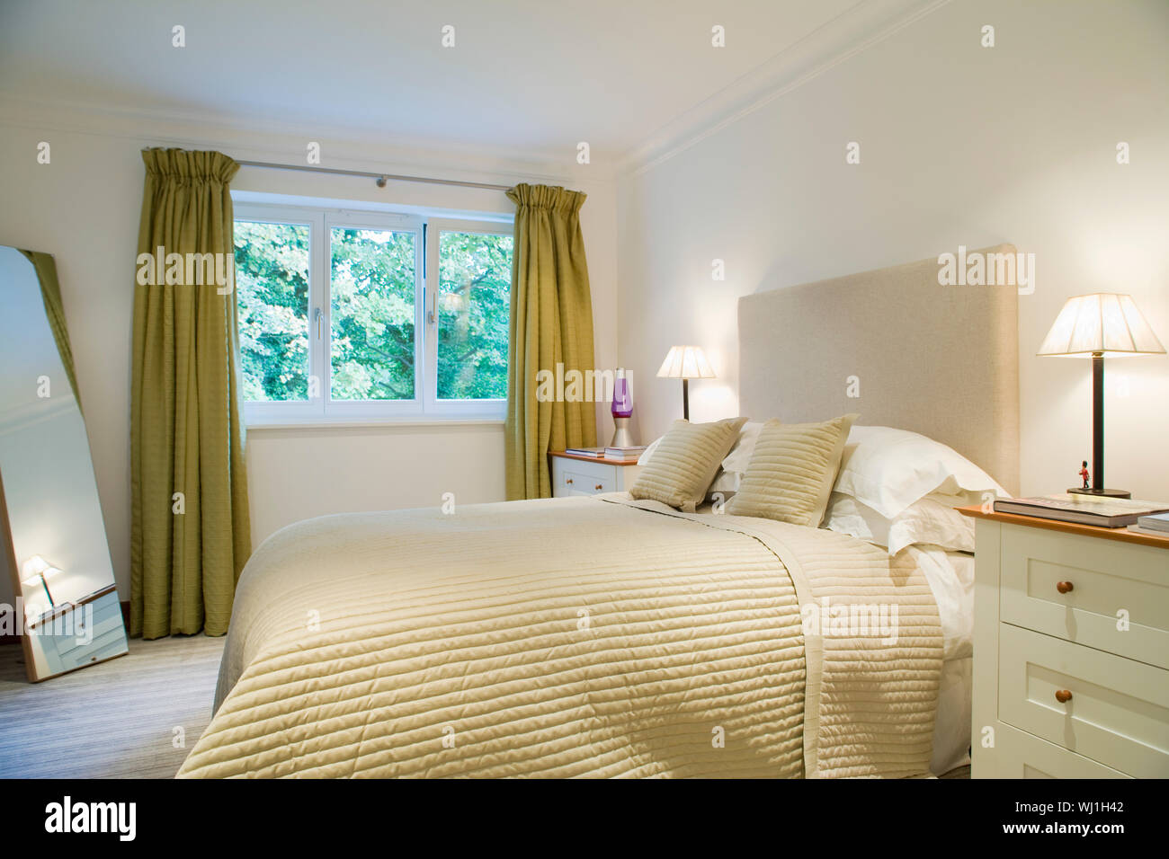 View of lit lamps by tidy bed Stock Photo - Alamy