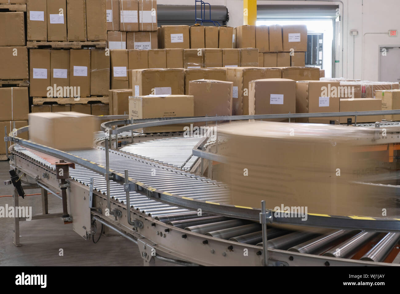 Cardboard boxes on conveyor belt in distribution warehouse Stock Photo ...