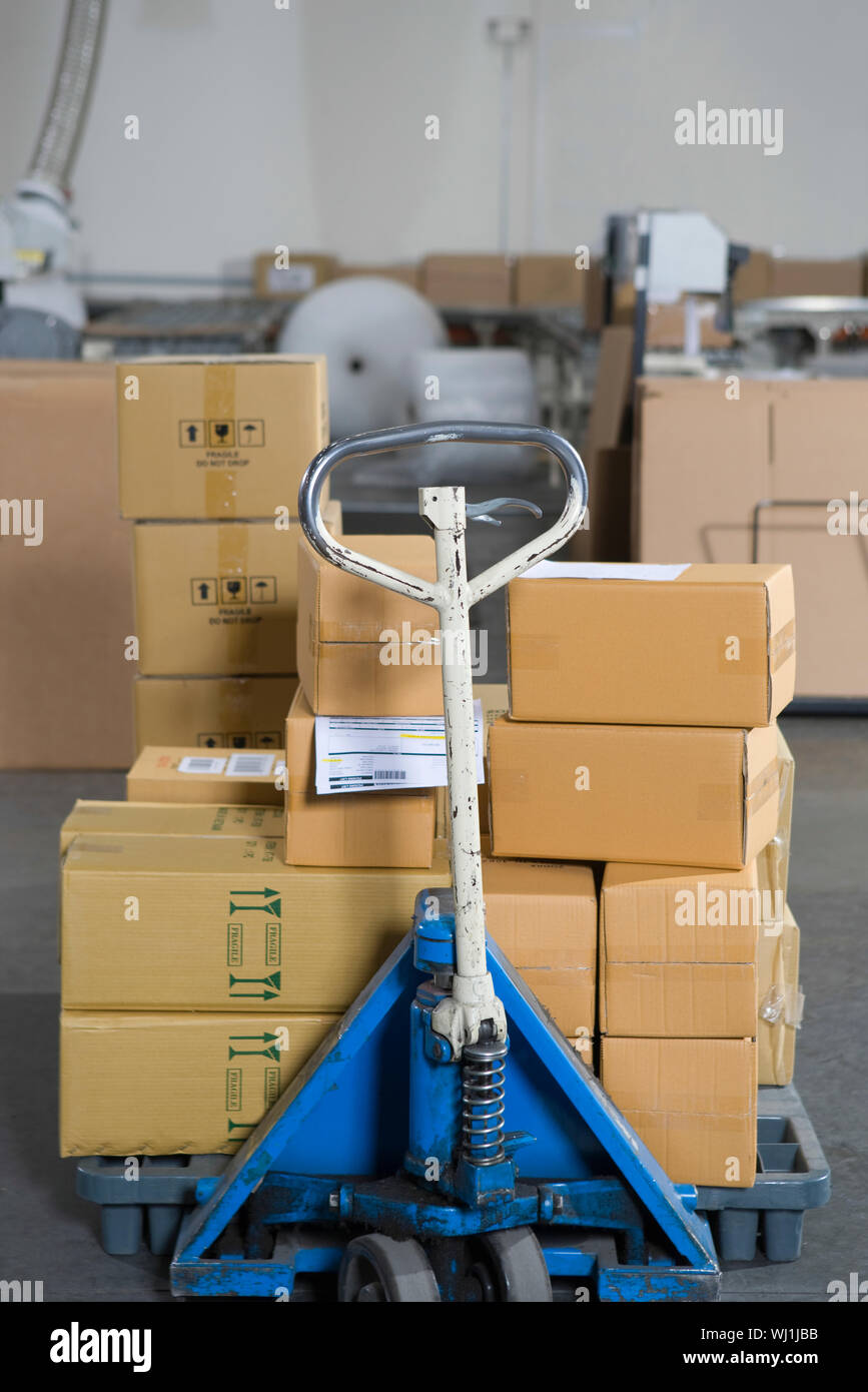 View of boxes stacked on trolley in distribution warehouse Stock Photo ...