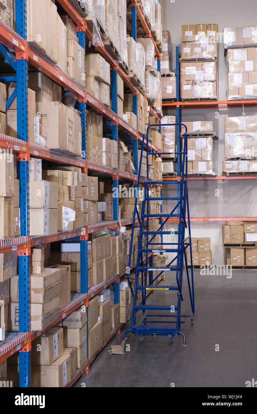 Cardboard boxes on shelves in distribution warehouse Stock Photo - Alamy