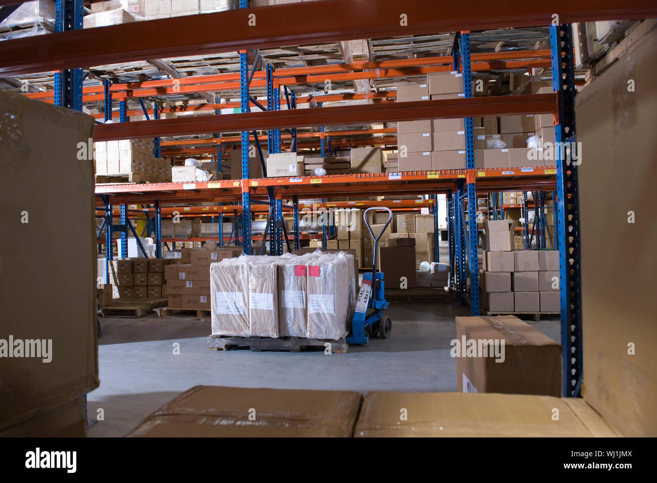 Cardboard boxes on shelves in distribution warehouse Stock Photo - Alamy