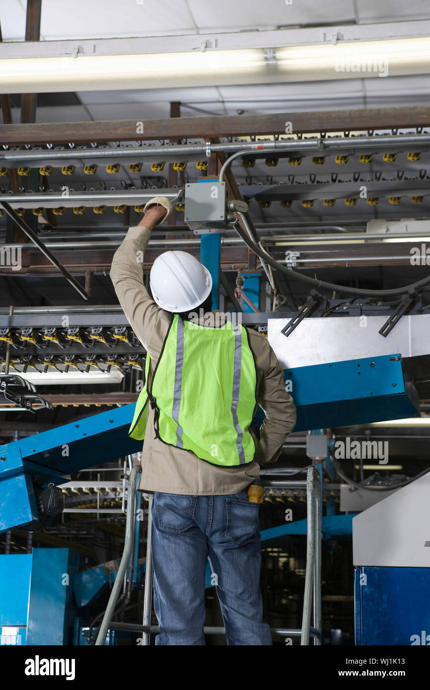 Rear view of a man working in printing press factory Stock Photo - Alamy