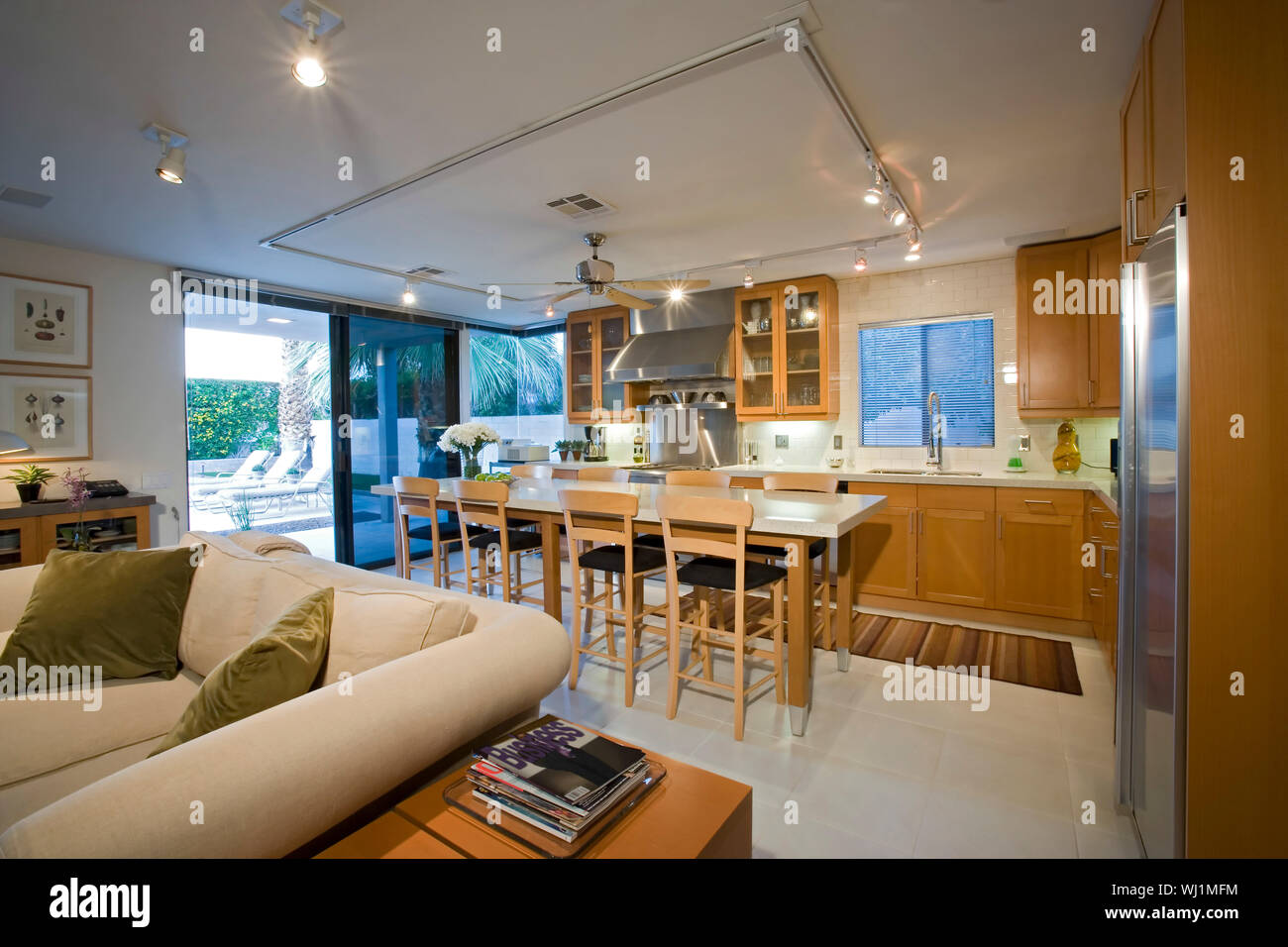 Dining table and kitchen with cropped view of sofa in foreground Stock ...