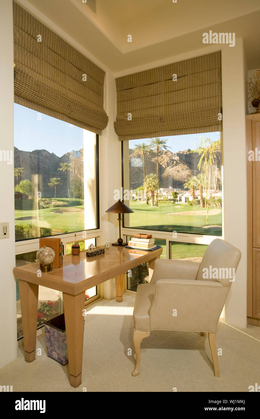 View of chair and table against window in study room Stock Photo - Alamy
