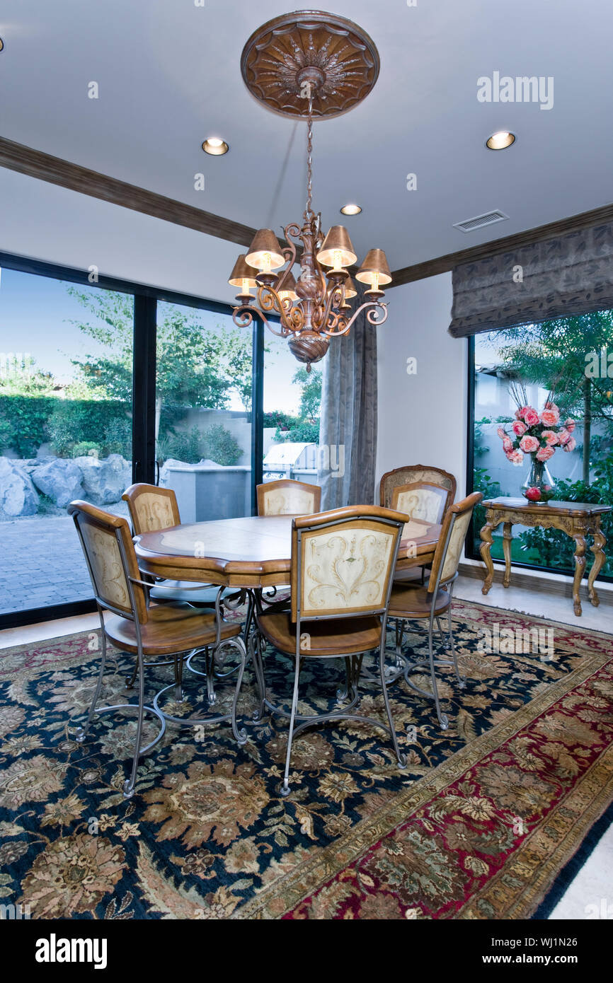 Lit chandelier hanging over table in hallway at modern home Stock Photo ...