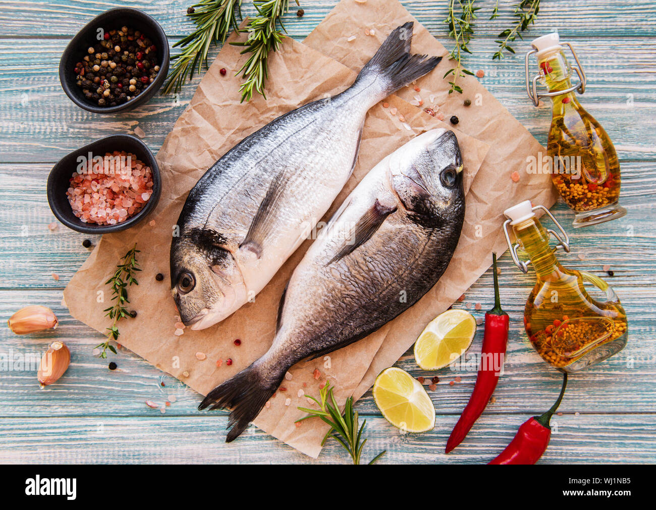 Fresh fish dorado. Dorado and ingredients for cooking on a table Stock ...