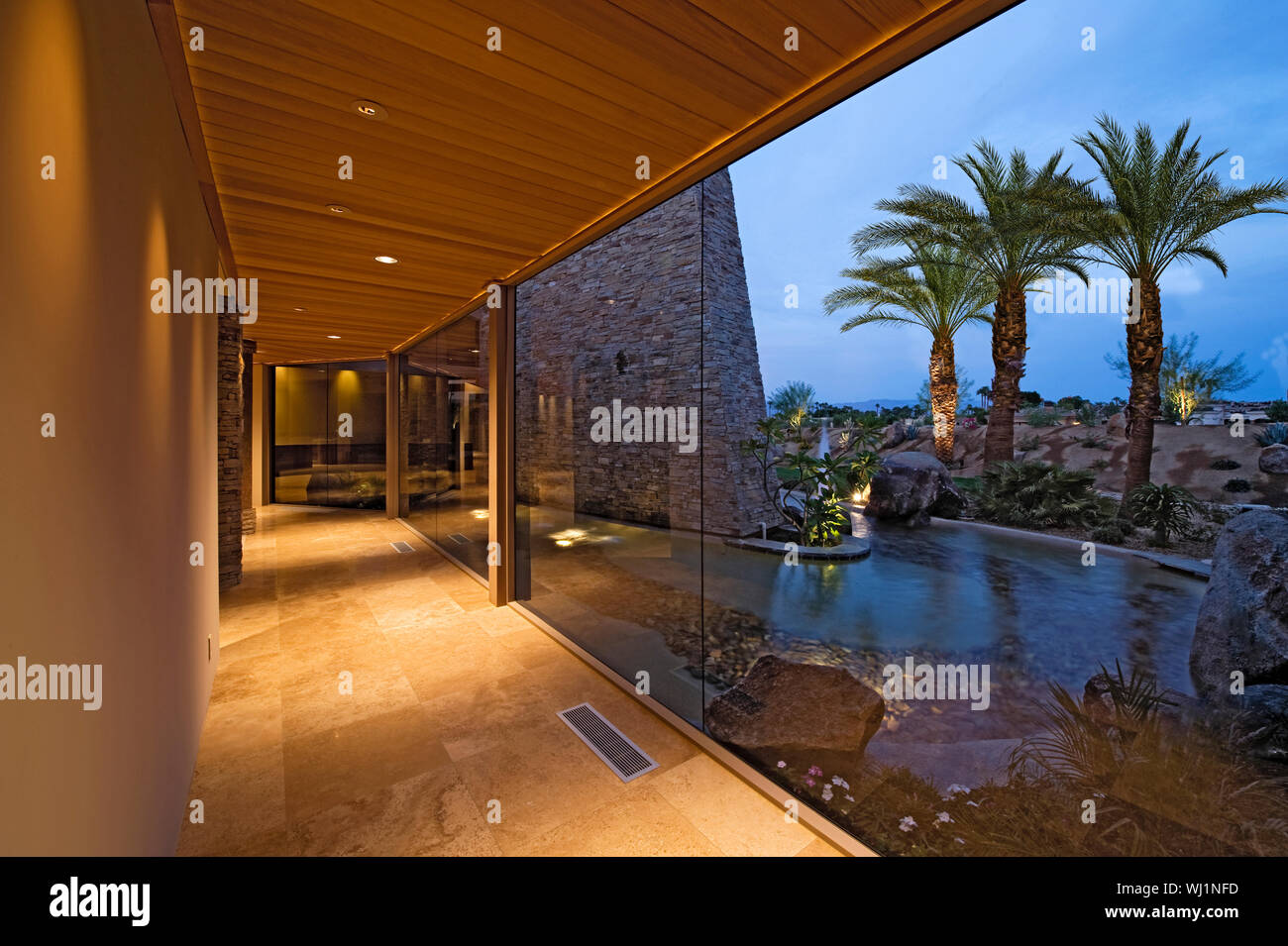 Empty corridor with view of pond through glass window in a modern house ...