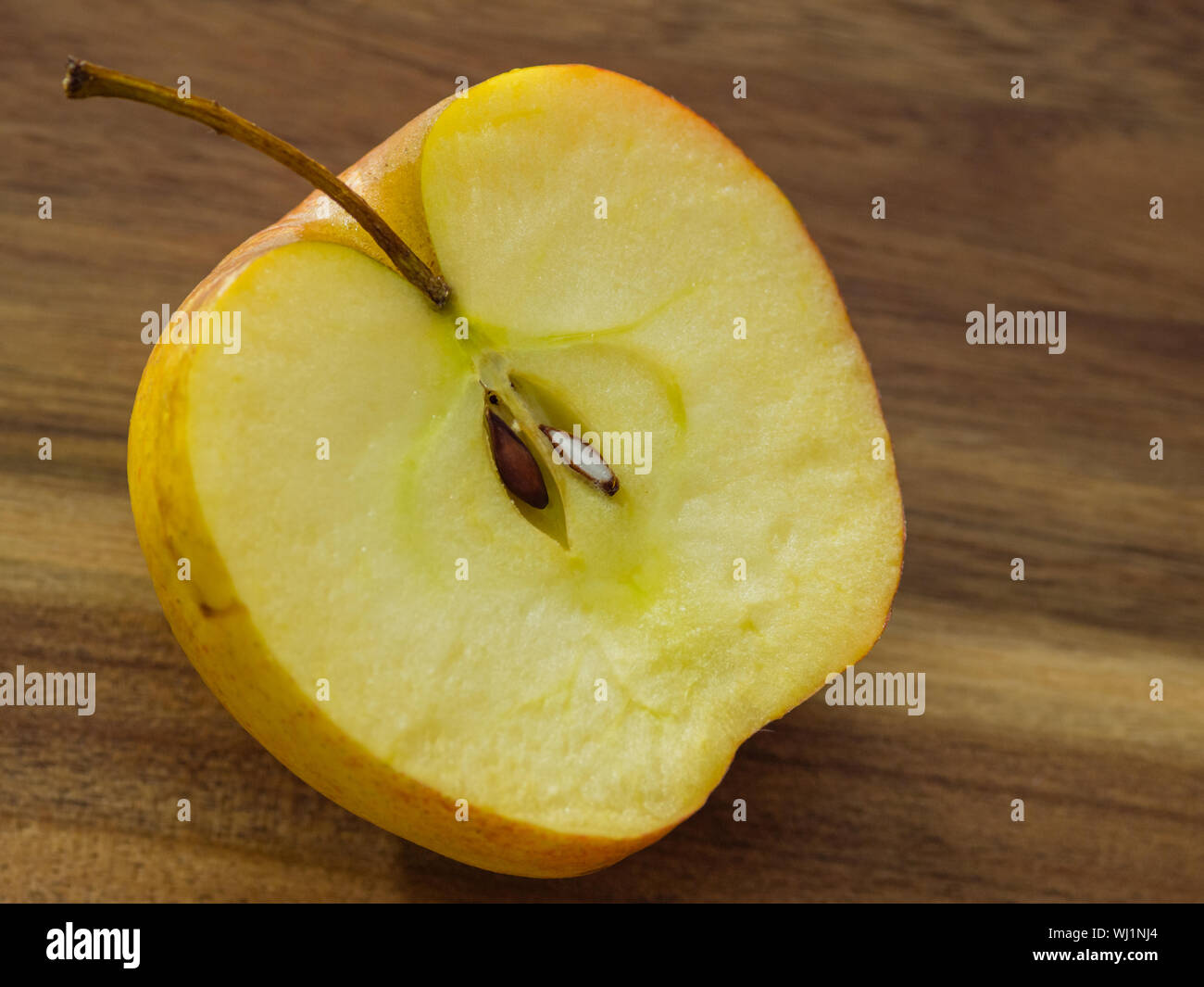 Apple cut in half with long brown stem, core and seeds isolated on ...
