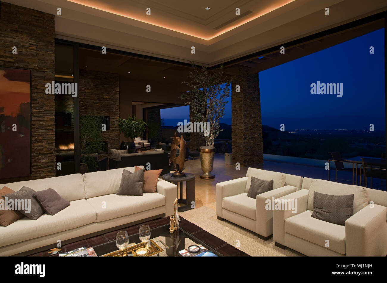 View of a luxury living room with night view through large window Stock ...