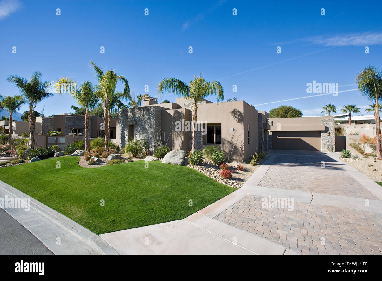View of a modern suburban house exterior with driveway in foreground ...