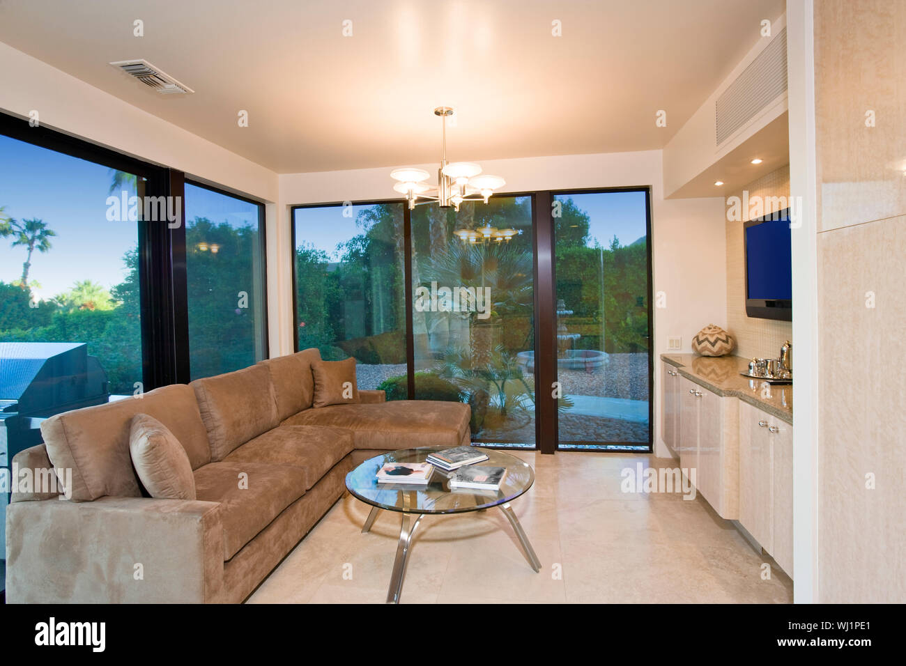 Modern living room with view of patio through windows Stock Photo - Alamy