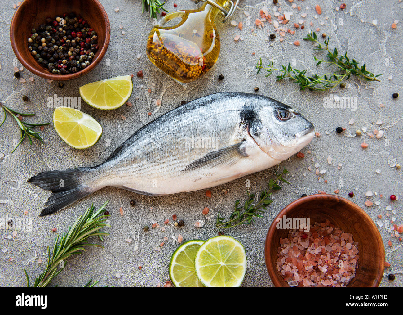 Fresh fish dorado. Dorado and ingredients for cooking on a table Stock ...