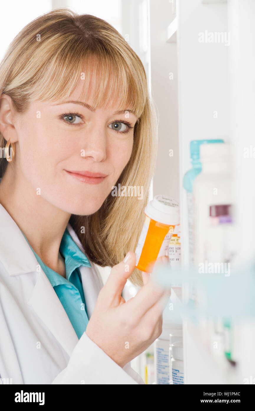 Portrait of a confident pharmacist holding medicine at workplace Stock ...