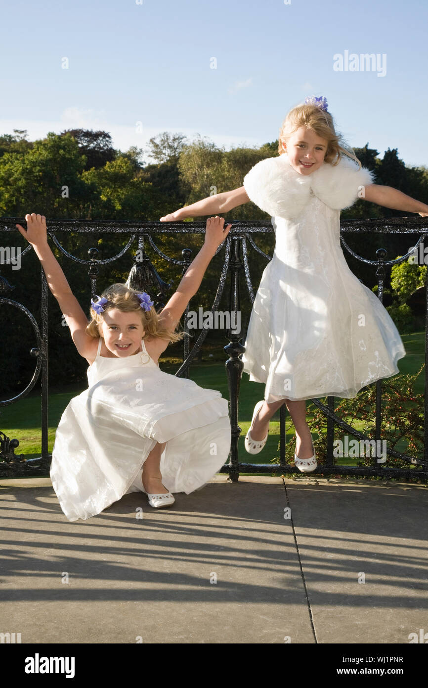 Full length portrait of two little flower girls waiting for wedding ...