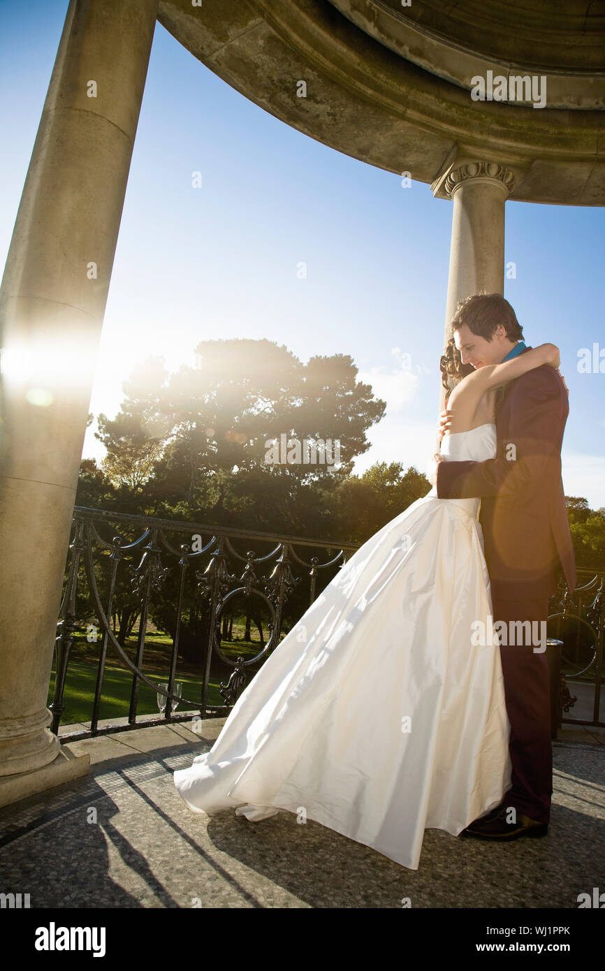 Full length side view of a young newlywed couple embracing Stock Photo ...