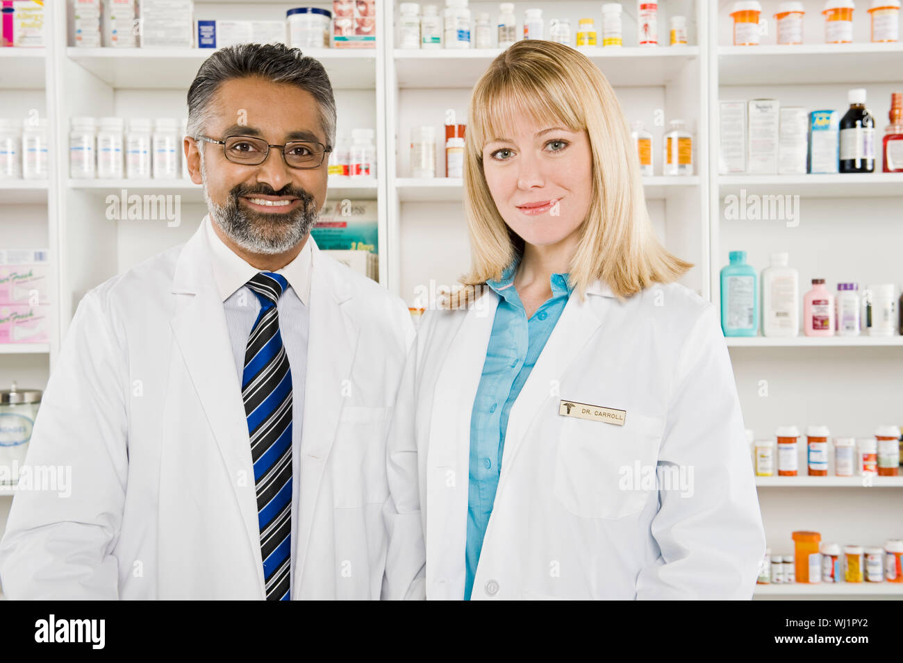 Portrait of a happy middle aged pharmacist standing with mature ...