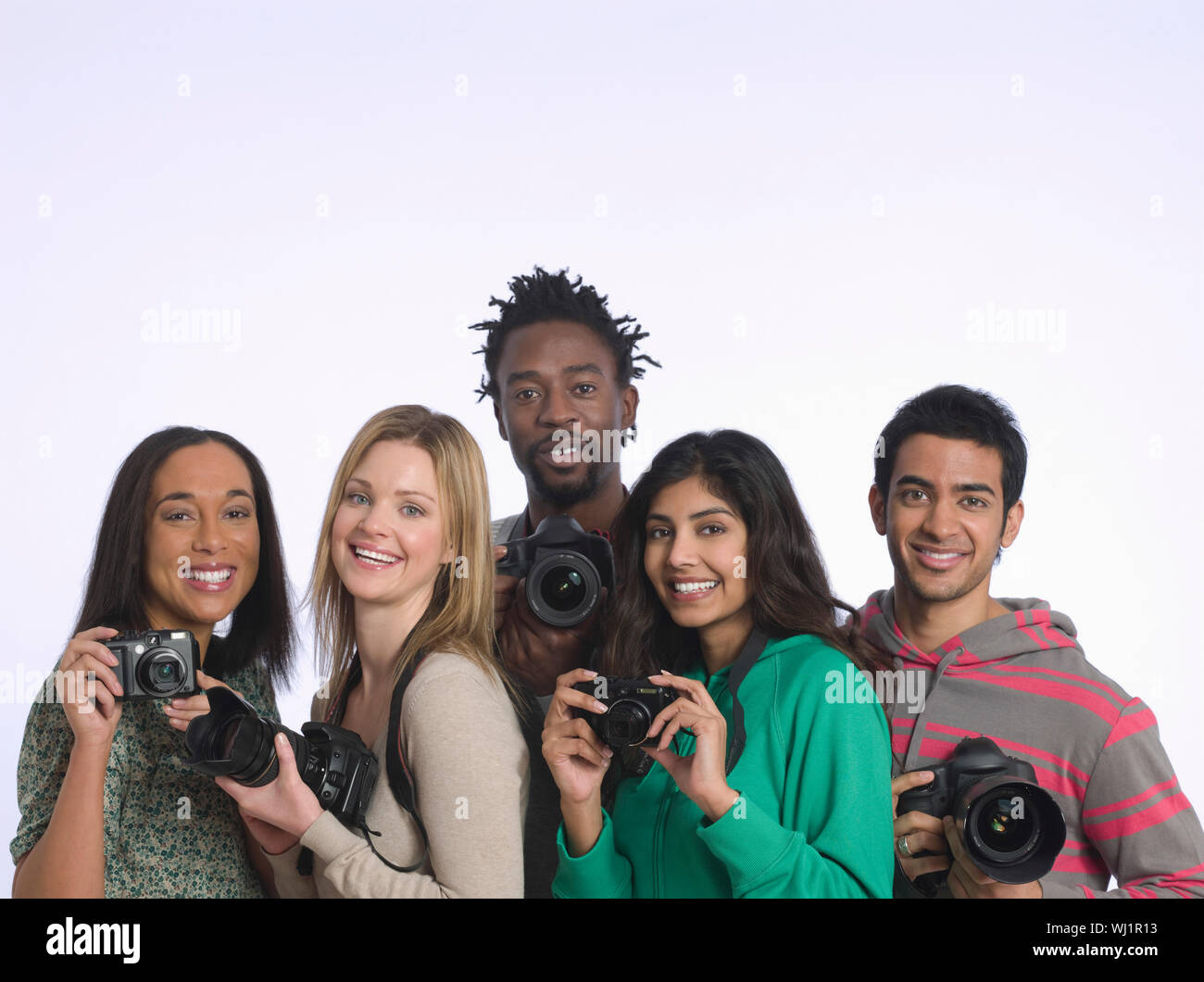 Group portrait of multiethnic young people holding cameras in studio ...