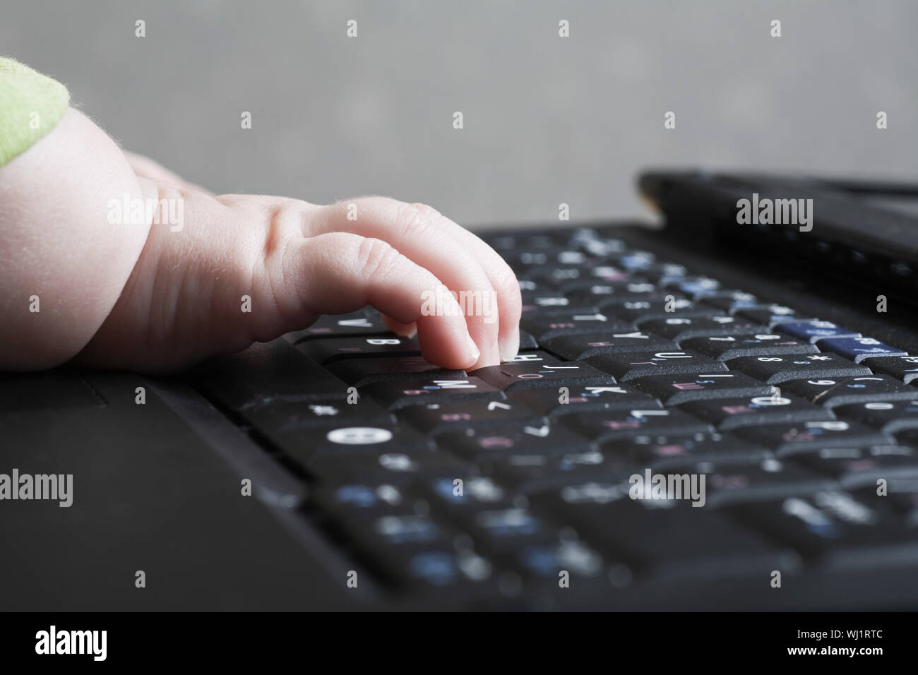 Baby touching laptop keyboard hi-res stock photography and images - Alamy