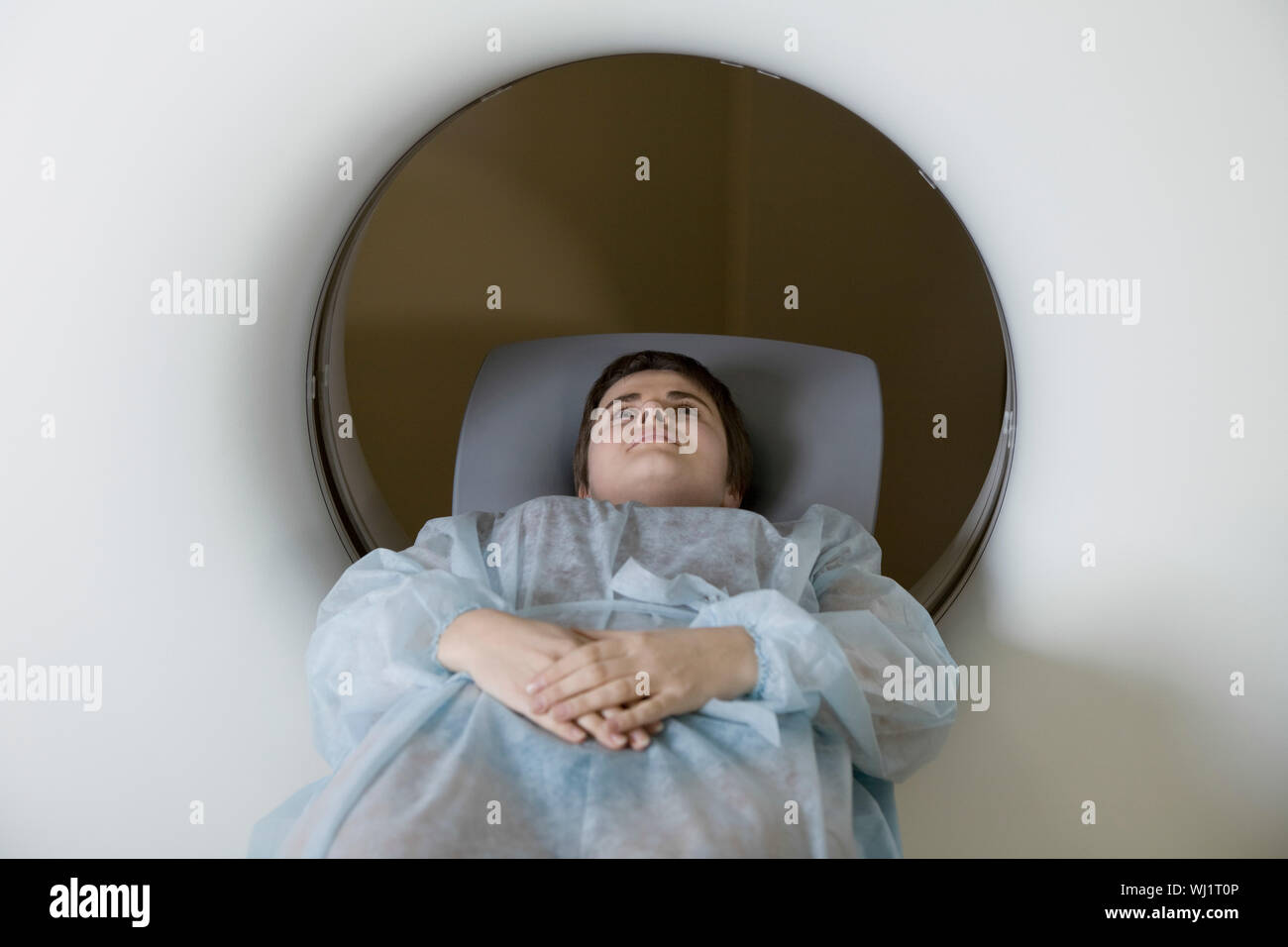 Young woman lying in front of CAT scan machine Stock Photo - Alamy