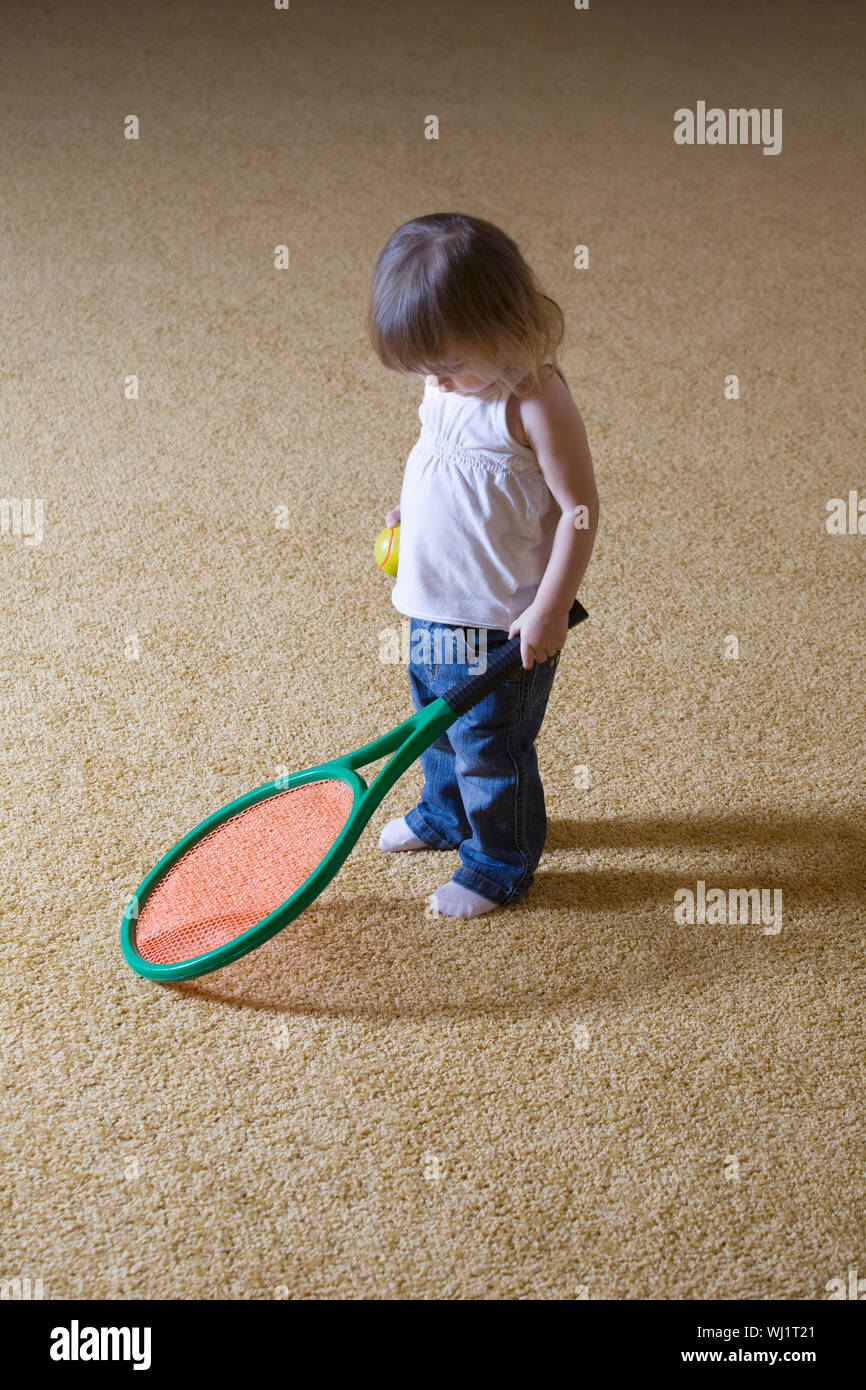 Full length of a baby girl holding tennis racket Stock Photo - Alamy