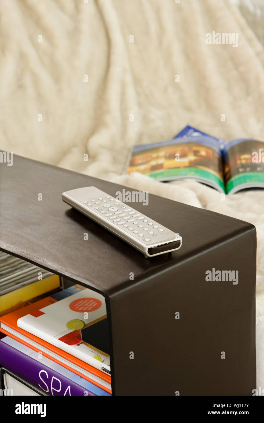 Closeup of a remote control on bookshelf Stock Photo - Alamy