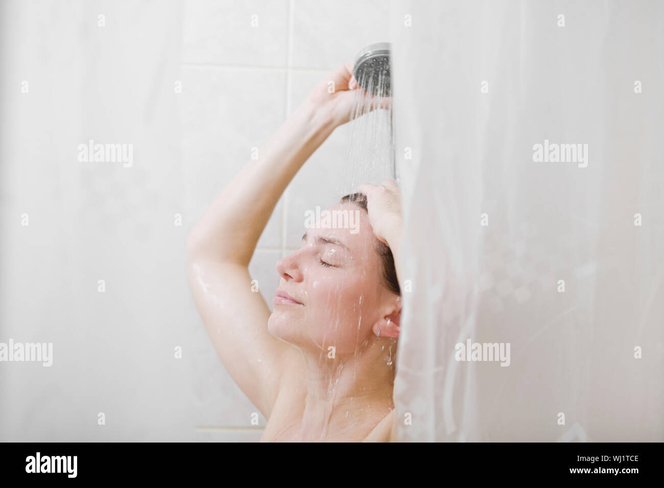 Closeup side view of a young woman taking shower Stock Photo - Alamy