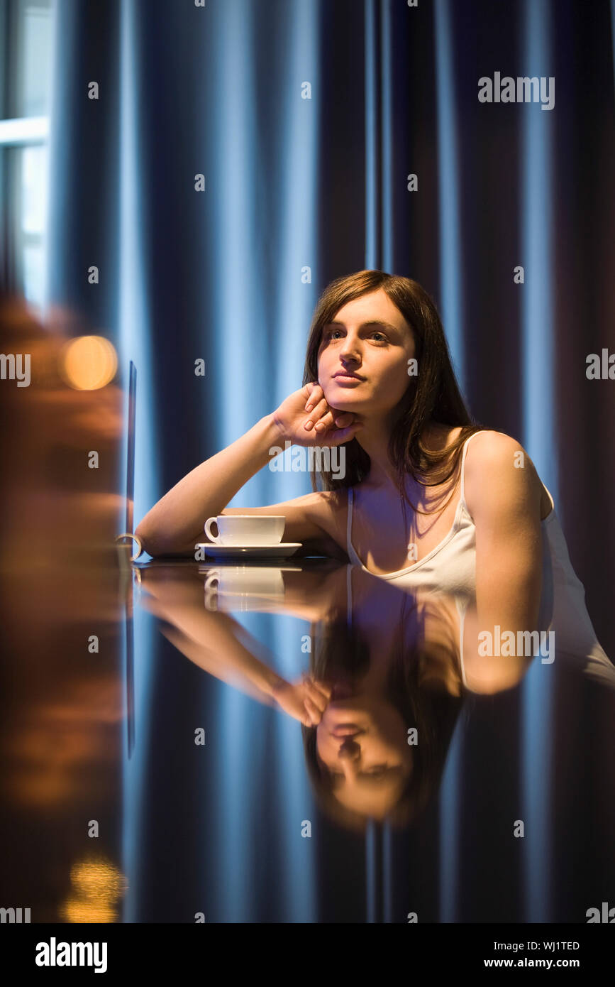 Thoughtful young woman with reflection on table relaxing in cafe Stock ...