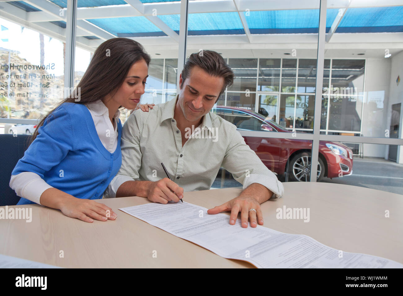 Signing papers at dealership hi-res stock photography and images - Alamy