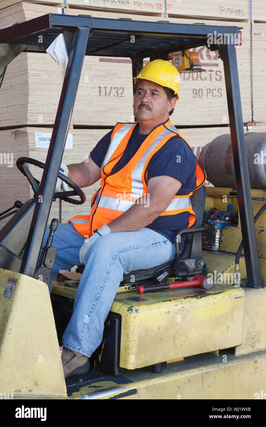 Forklift driver driving in warehouse Stock Photo - Alamy