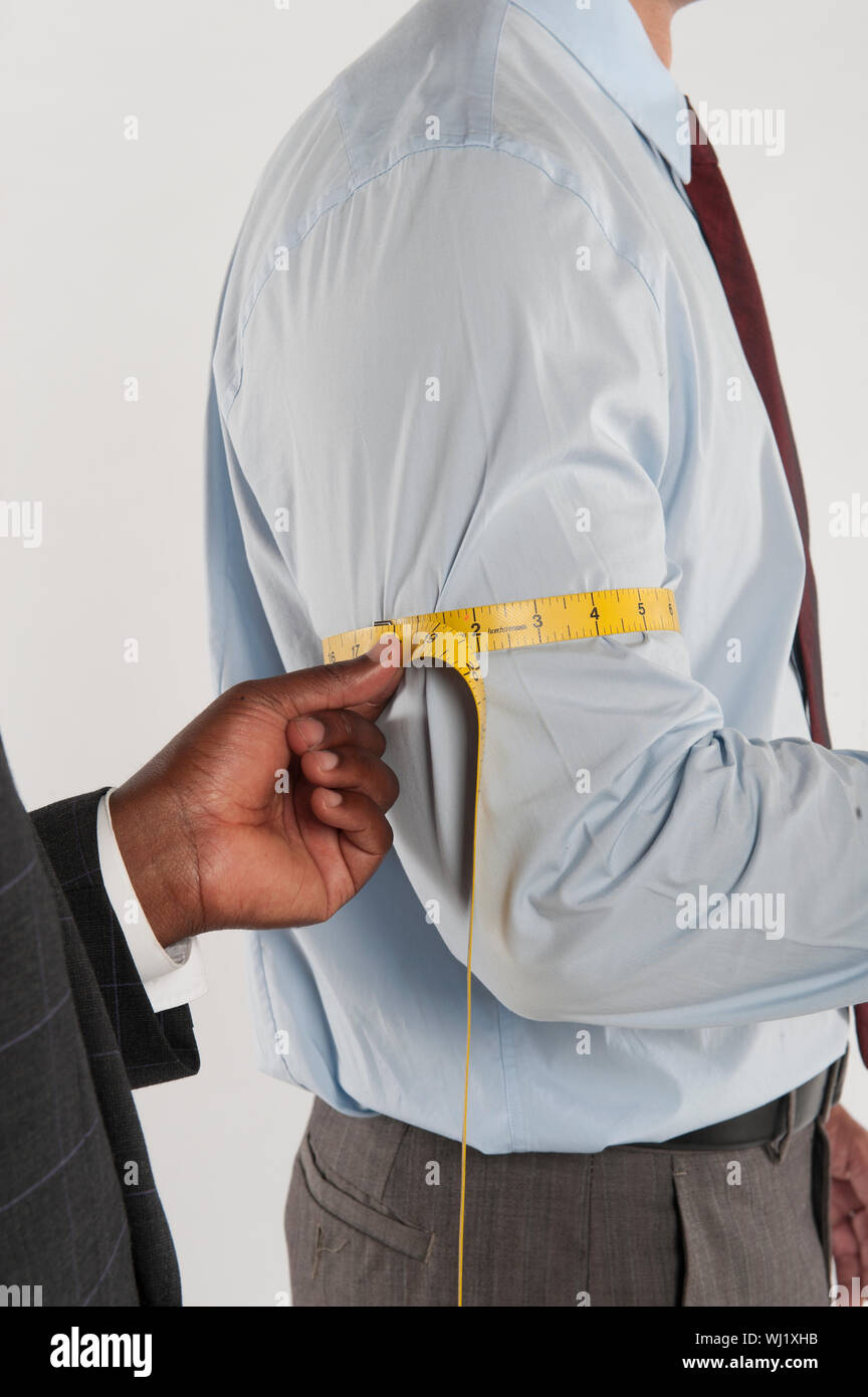 Tailor taking the measurement of a customer Stock Photo - Alamy