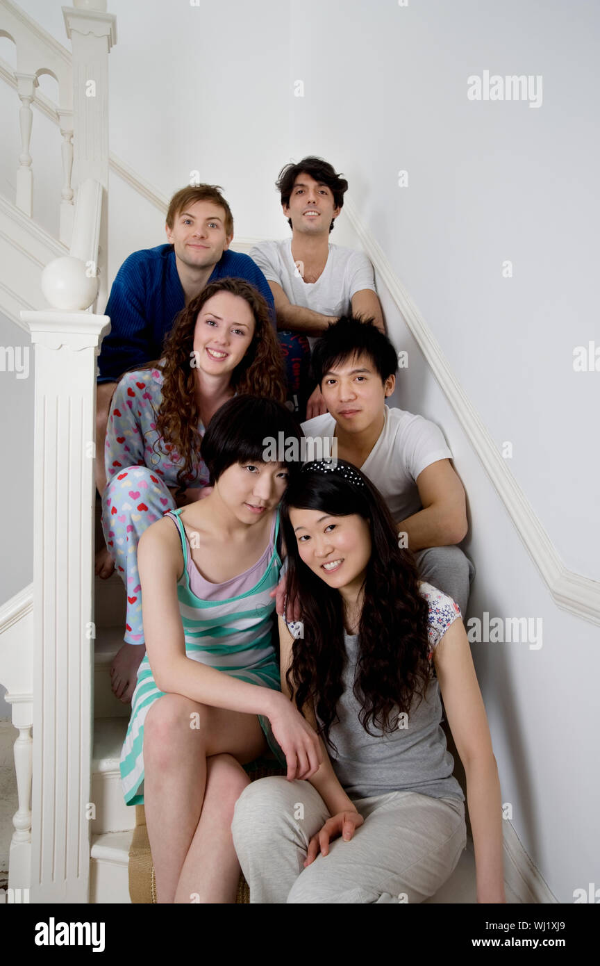 Group portrait of young friends sitting in stairway Stock Photo - Alamy