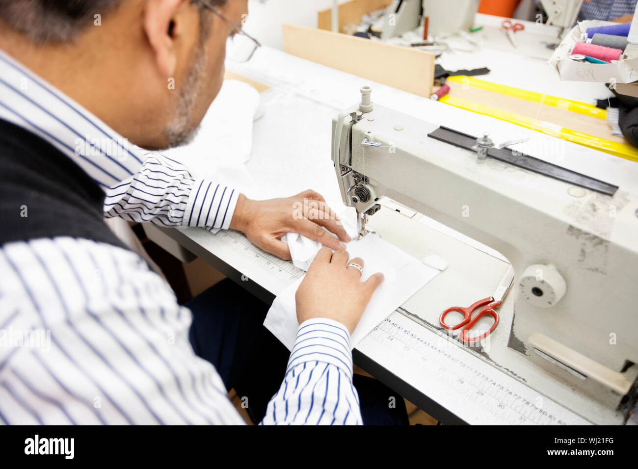 Close-up of man sewing with machine Stock Photo - Alamy
