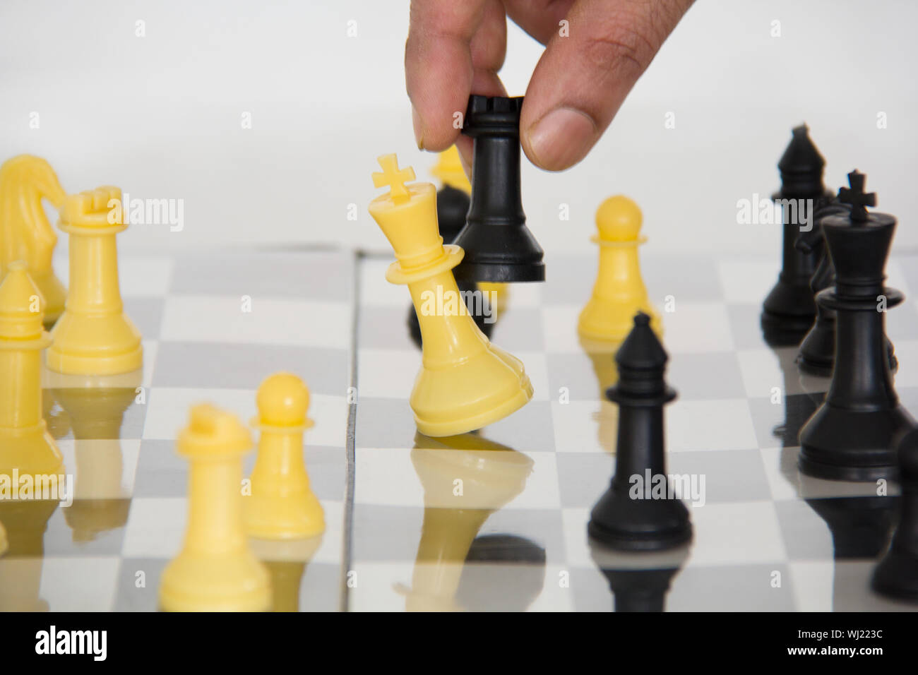 Man,s hand going for checkmate using his black rook to knock over the ...