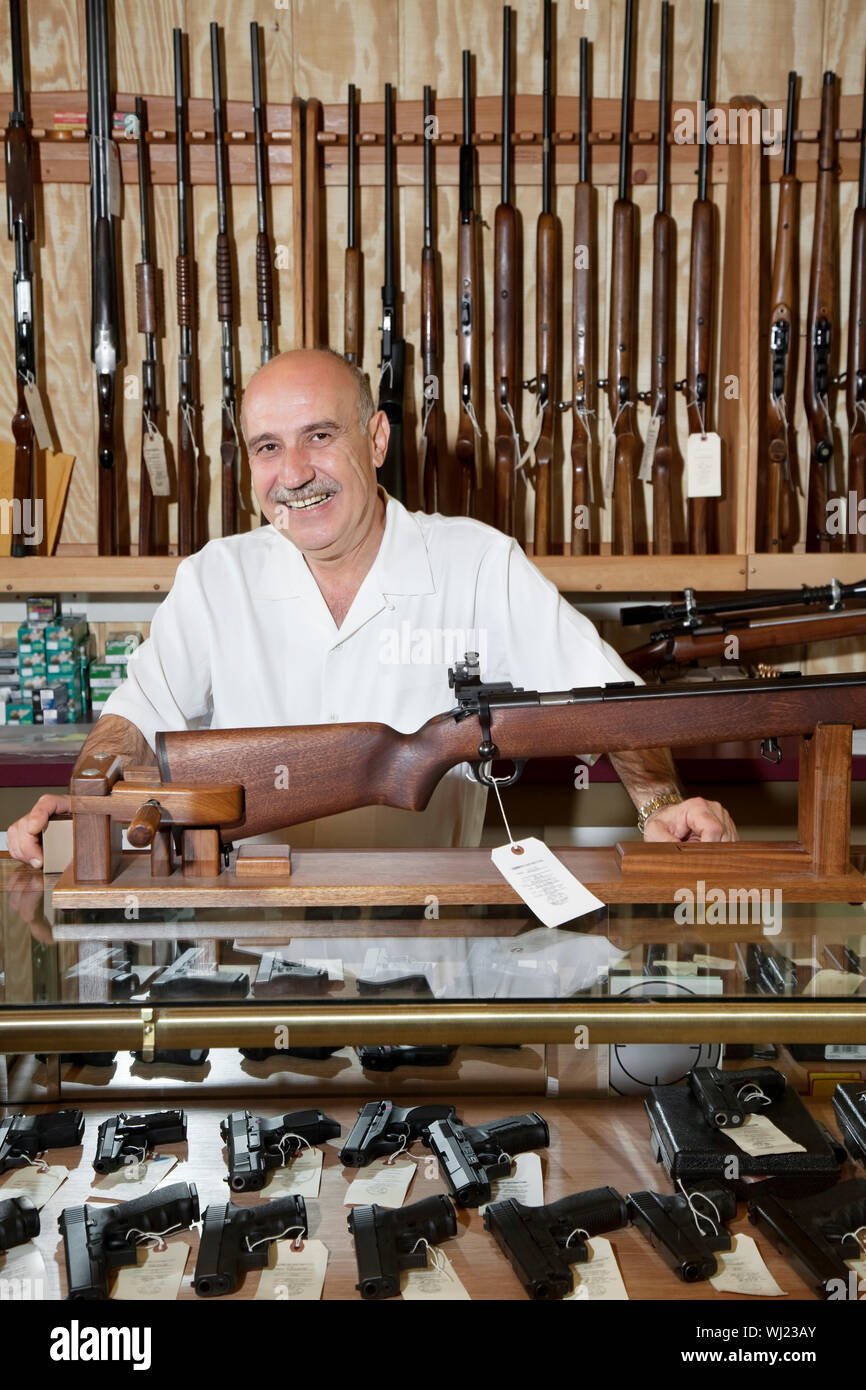 Portrait of happy mature owner of gun shop Stock Photo - Alamy