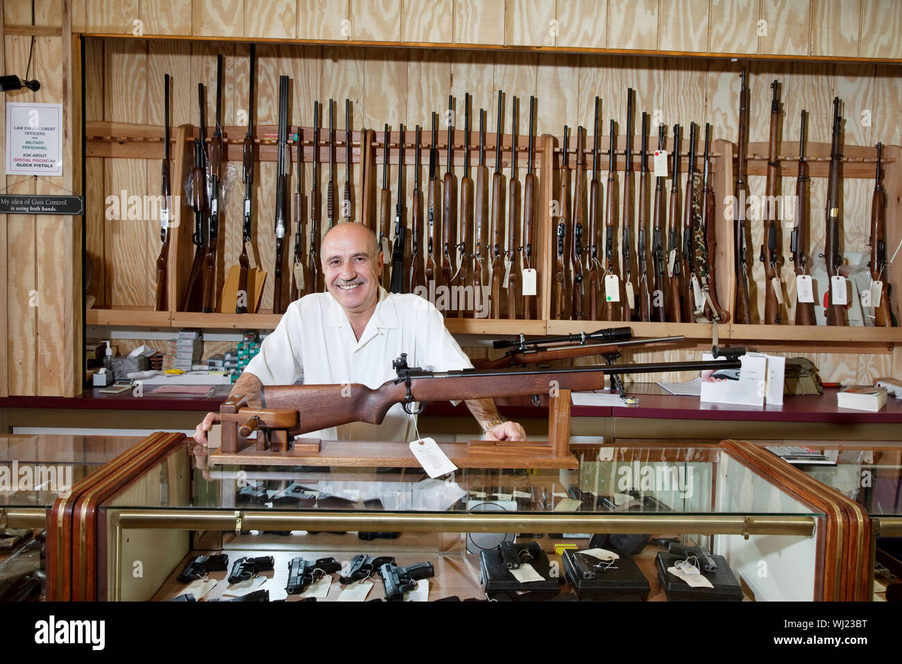 Portrait of happy mature owner of gun shop Stock Photo - Alamy