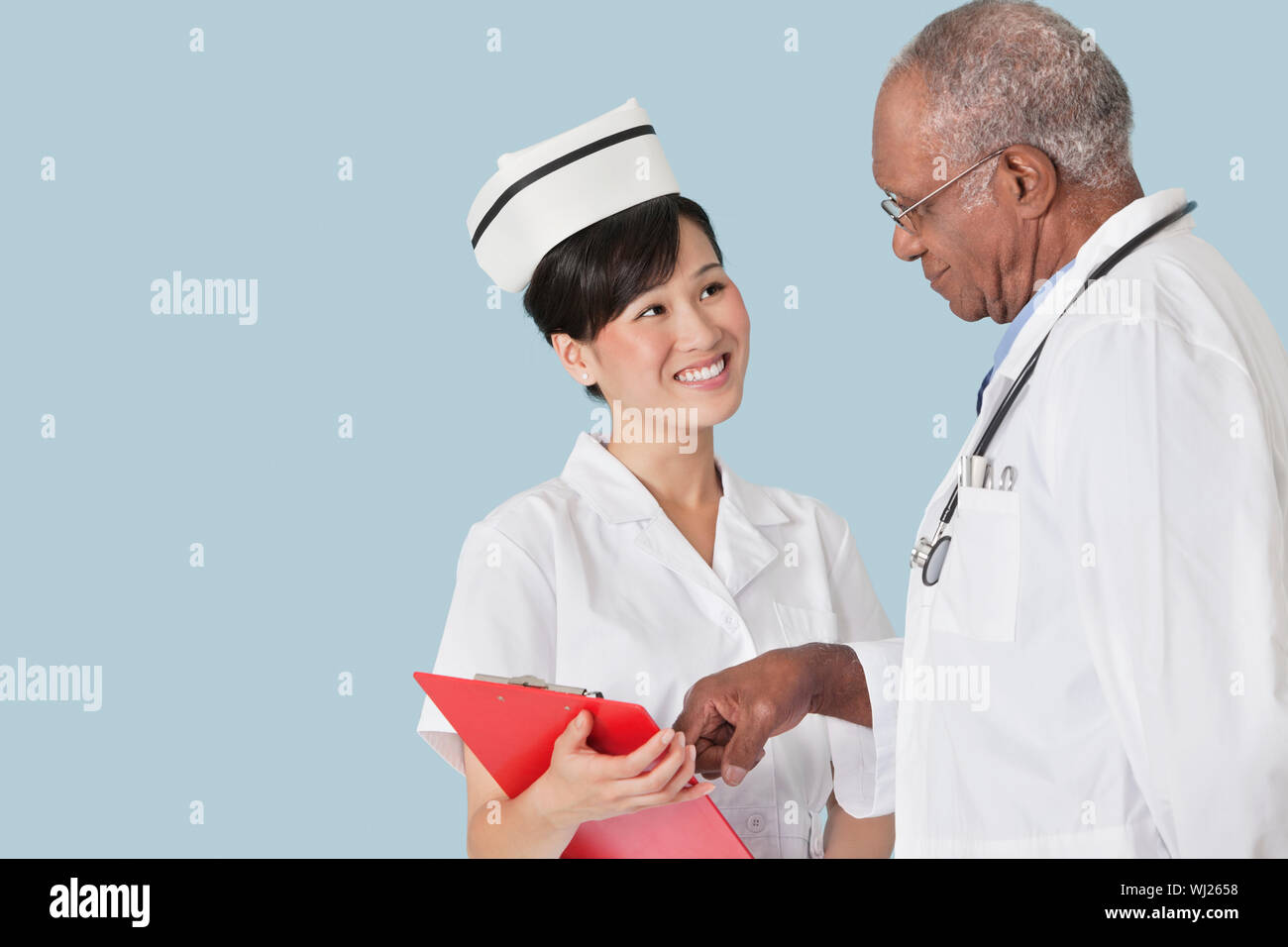 Two health professionals having a discussion over medical report ...