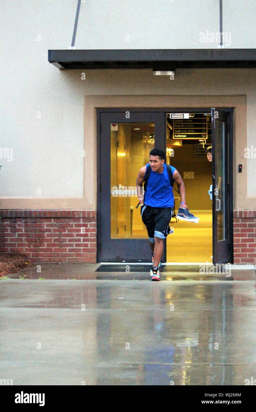 Full Length Of Young Man At Building Entrance Stock Photo - Alamy