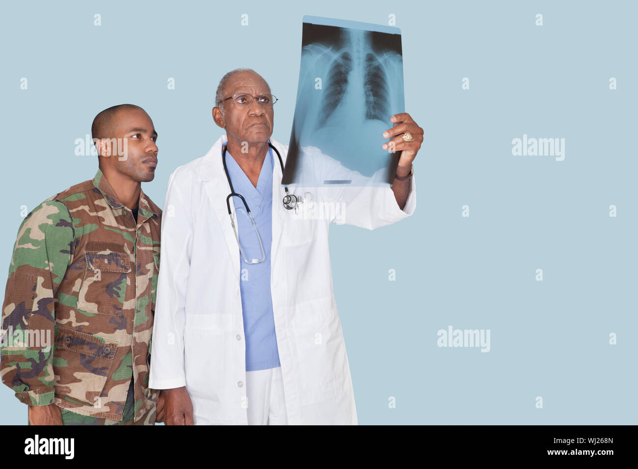 Senior doctor with US Marine Corps soldier looking at x-ray report over ...