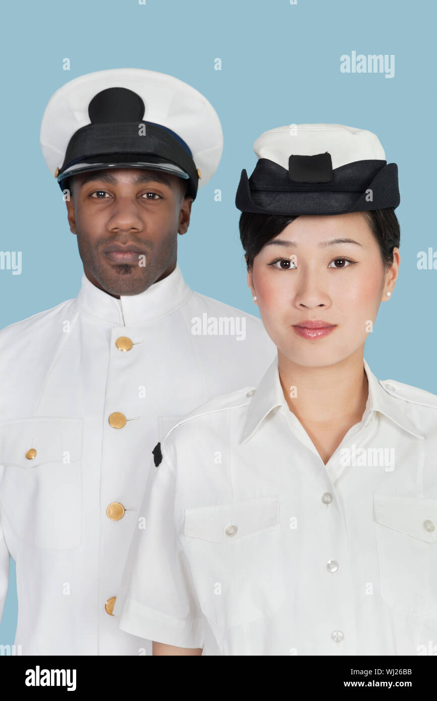 Portrait of two confident young Navy officers over light blue ...