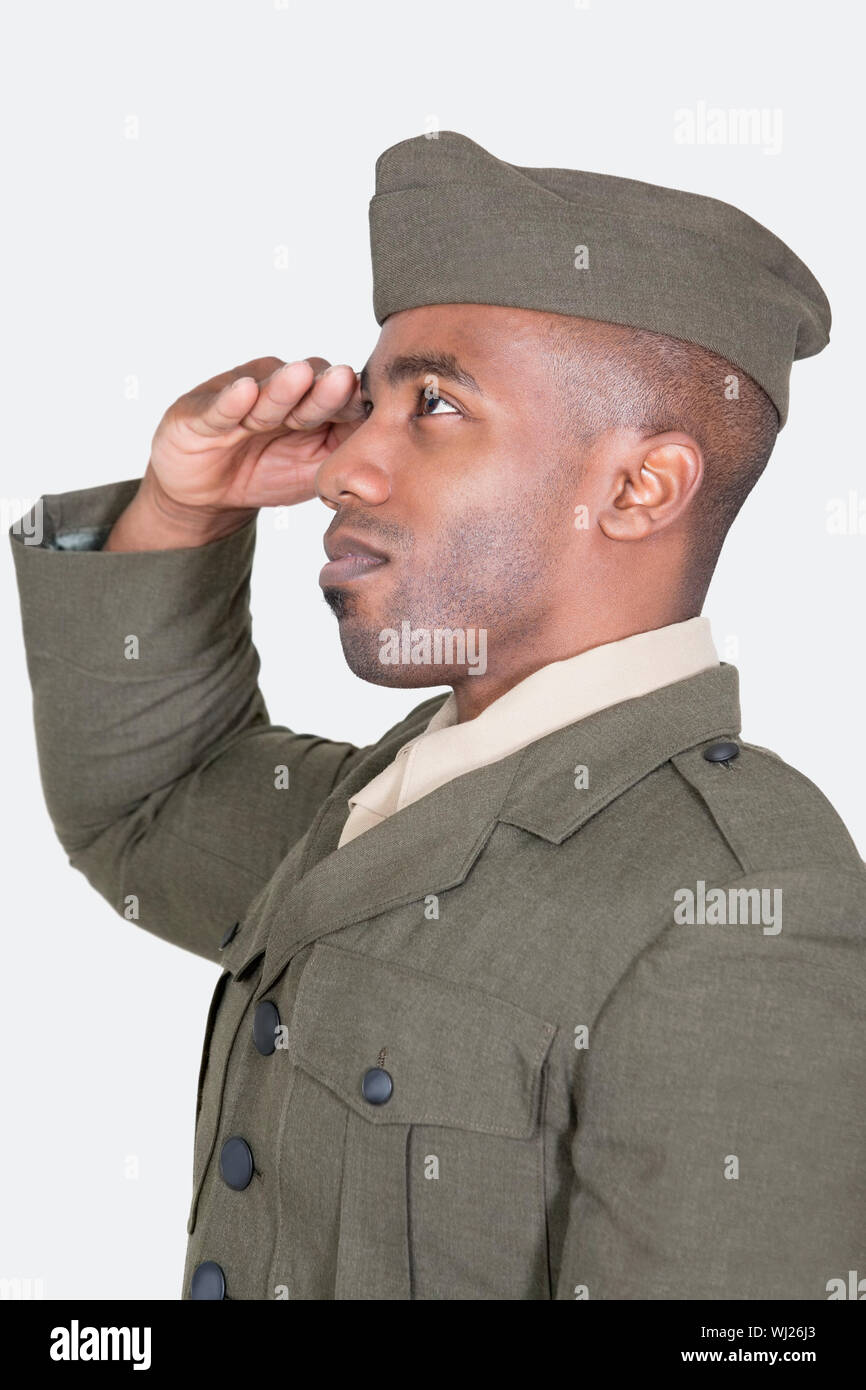 Side view of confident soldier saluting over gray background Stock ...