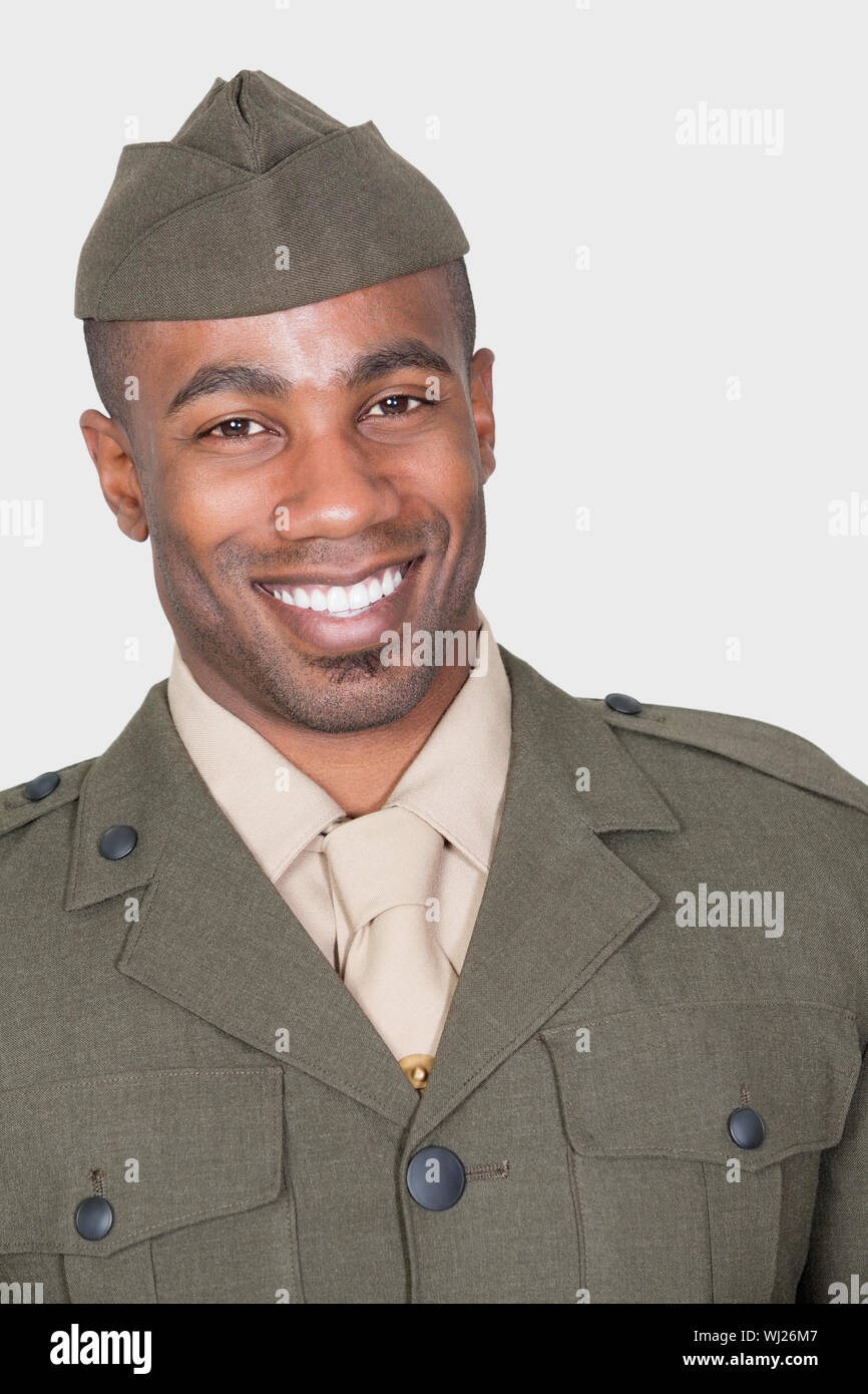 Portrait of male African American soldier smiling over gray background ...