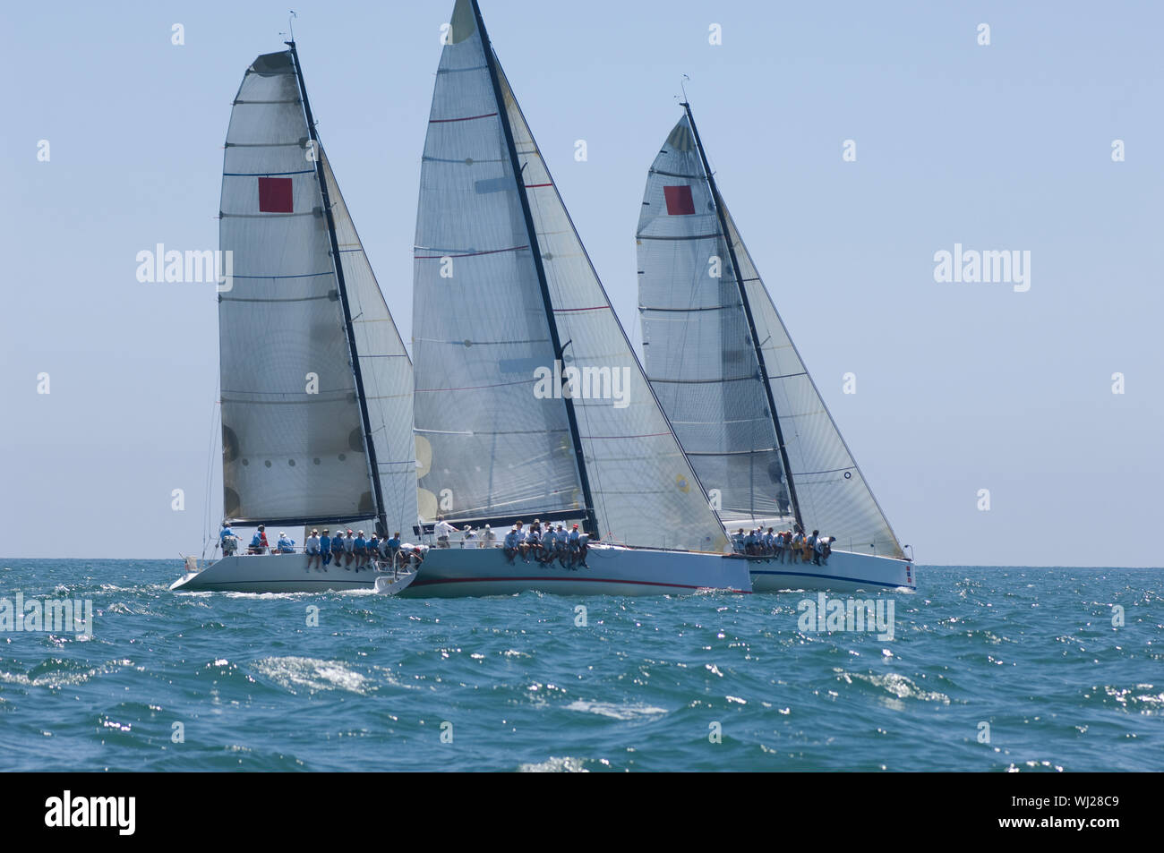 View of three yachts compete in team sailing event Stock Photo - Alamy