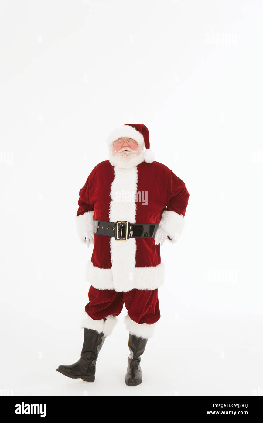 Portrait of a senior Santa Claus standing with hands on hip isolated ...