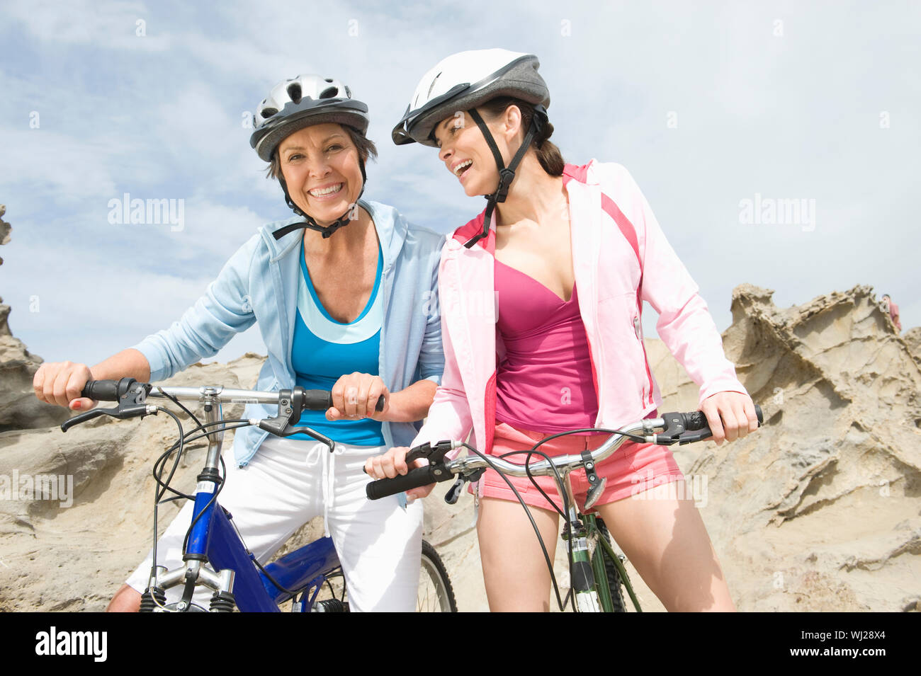 Portrait of a happy mother with daughter riding bicycle Stock Photo - Alamy