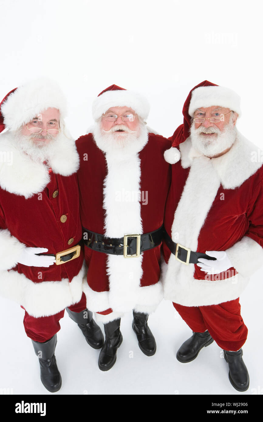 Portrait of three happy senior Santa Claus standing together isolated ...