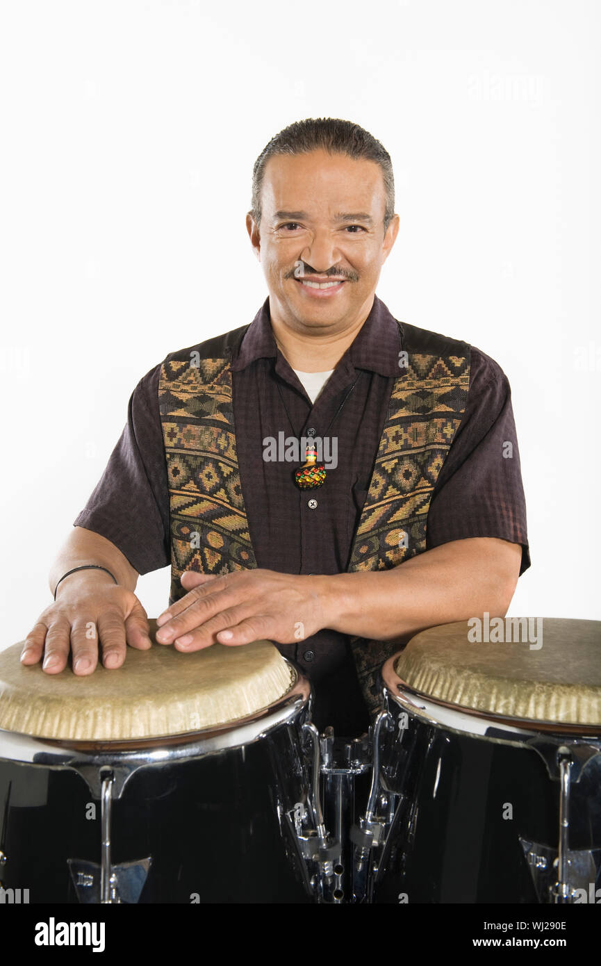 Portrait of a happy senior artist playing drums isolated over white ...