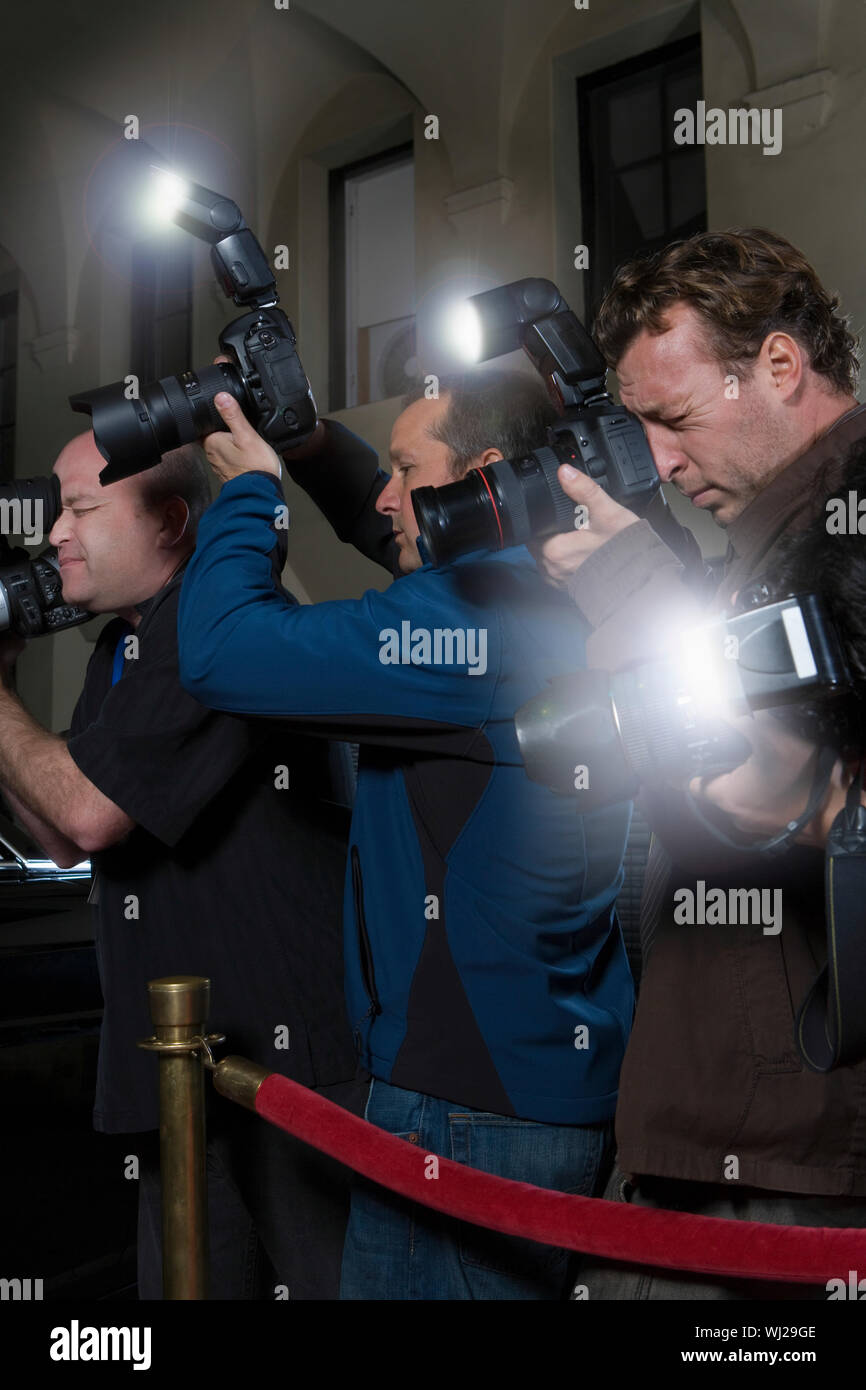 Side view of photographers across rope barrier at media event Stock ...