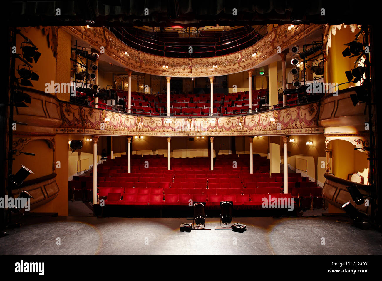 View of an empty theatre with red seats and balcony Stock Photo - Alamy